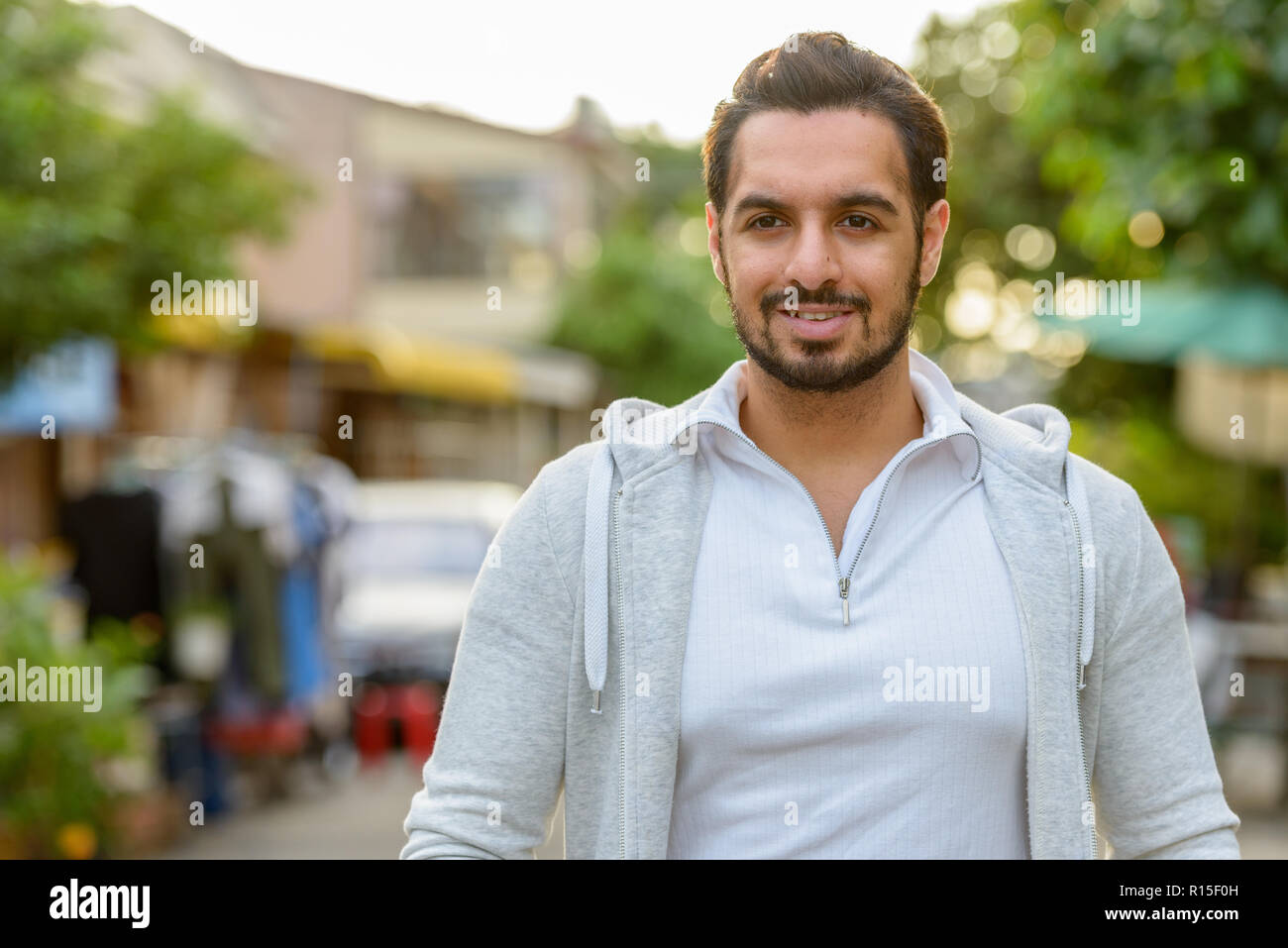 Portrait of young happy Indian man smiling outdoors Stock Photo - Alamy
