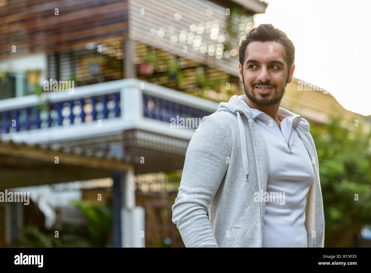 Portrait of young happy Indian man thinking outdoors Stock Photo - Alamy