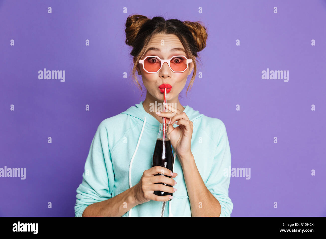 Portrait of a pretty young girl with bright makeup isolated over violet ...