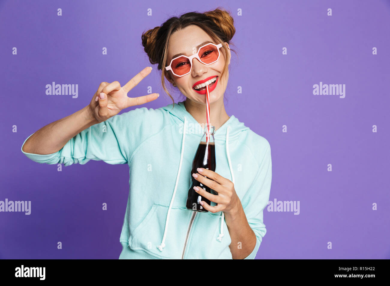 Portrait of a funny young girl with bright makeup over violet ...