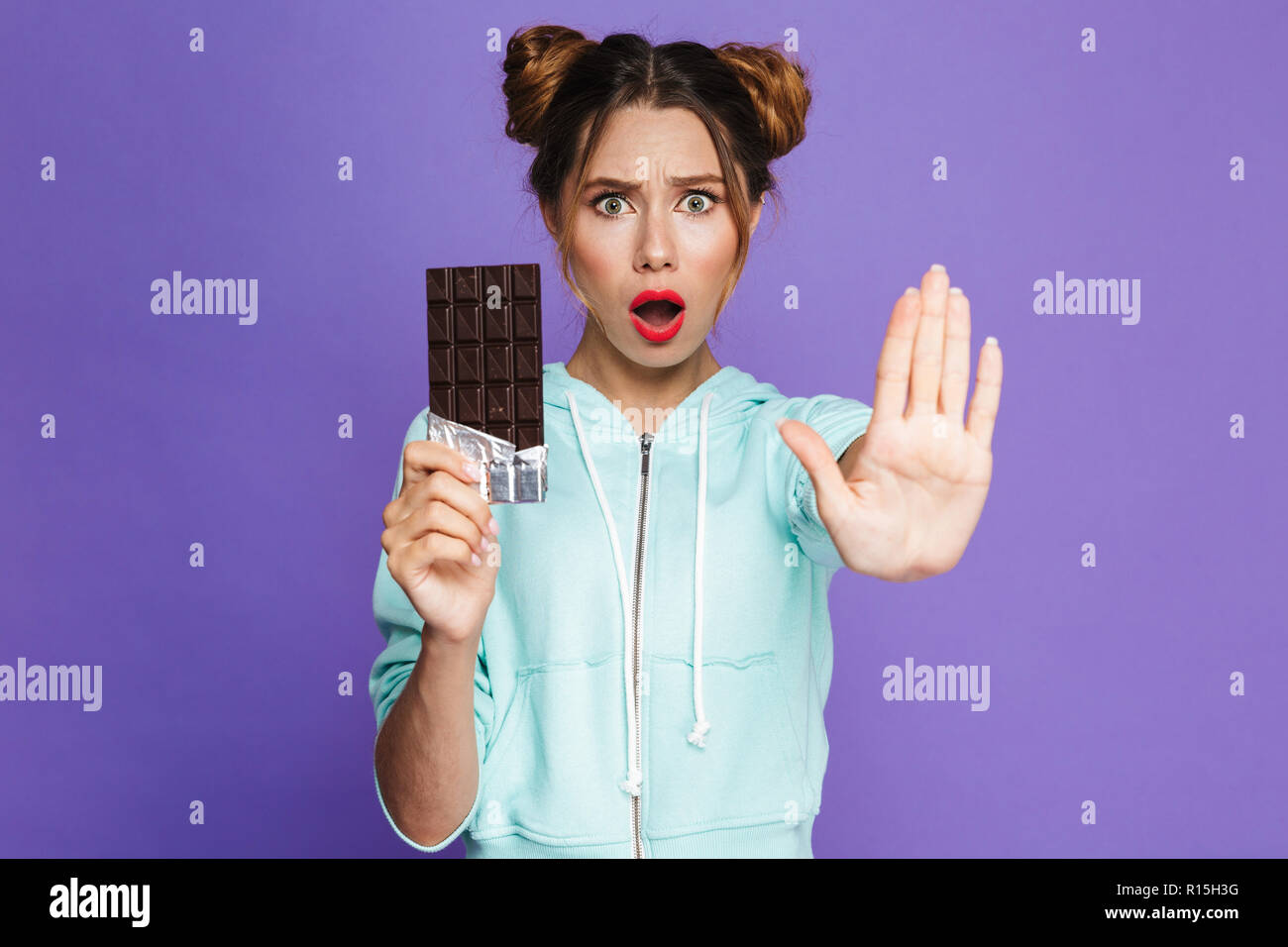 Portrait of an upset young girl with bright makeup over violet ...