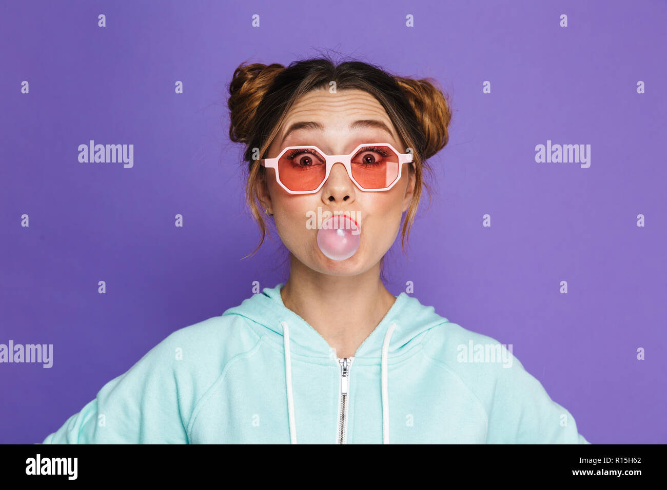 Portrait of a pretty young girl with bright makeup over violet ...