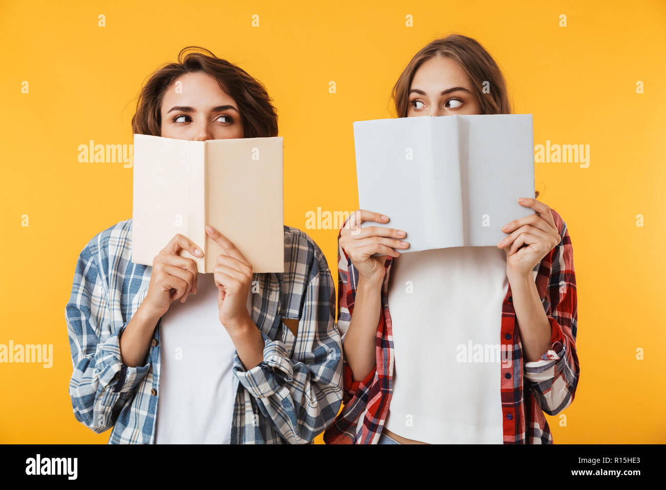 Photo of young women friends posing isolated over yellow background ...