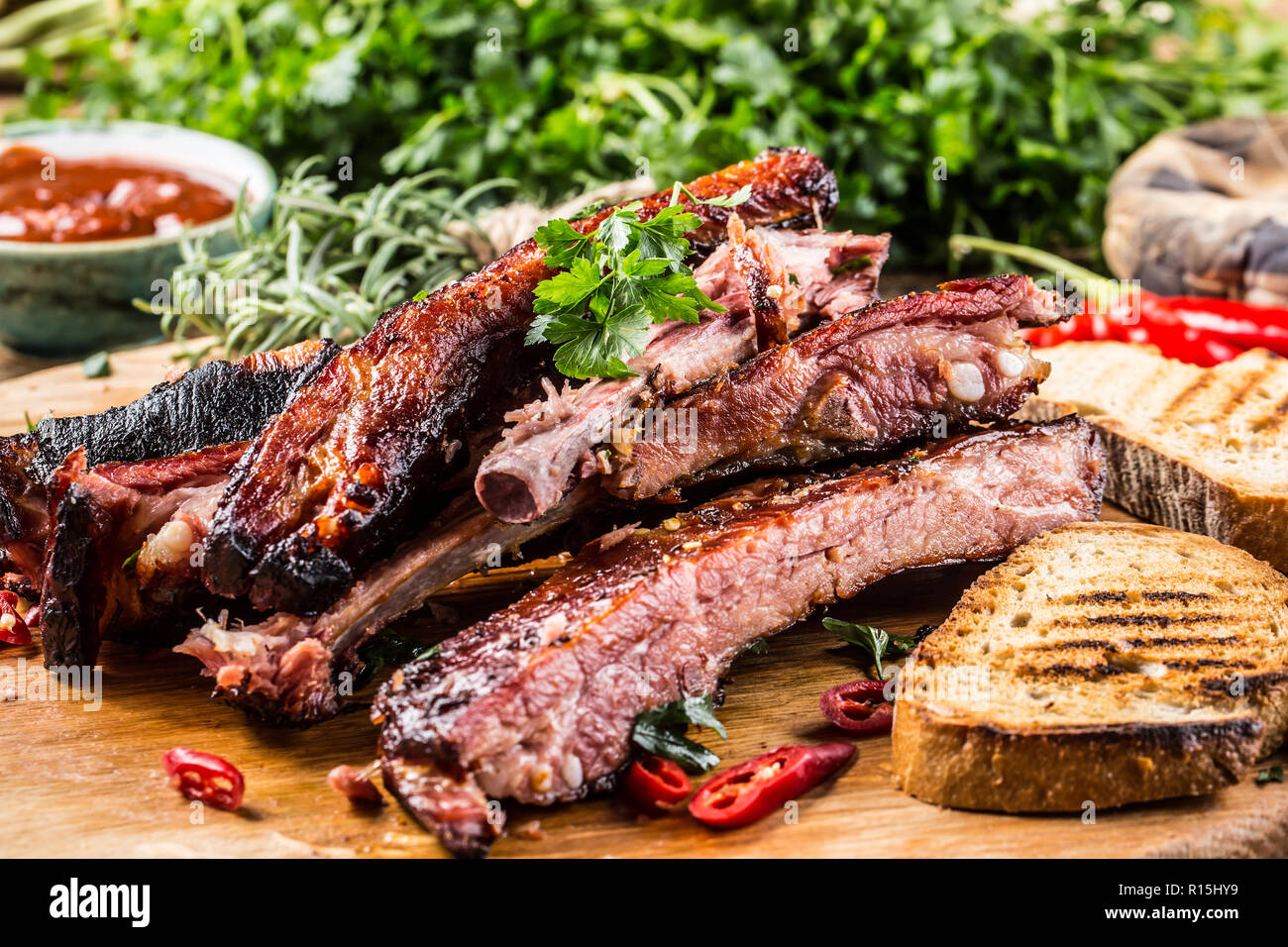 Tasty barbecue grilled pork ribs with chili pepers and parsley herbs ...