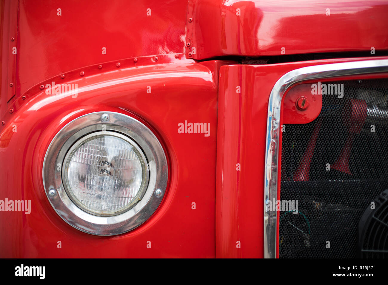 Detail of a red double decker bus headlight Stock Photo - Alamy