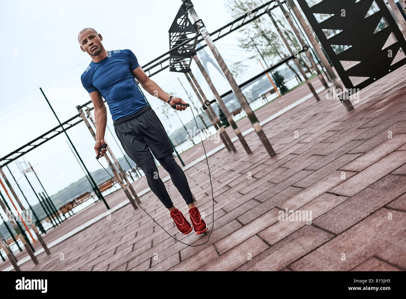 Muscular black man skipping rope. Portrait of muscular young man ...