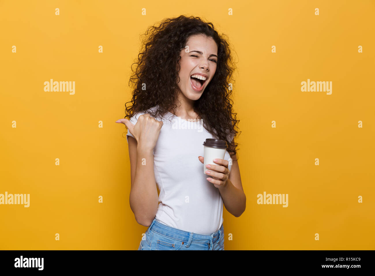 Image of pretty young woman 20s with curly hair smiling and holding ...