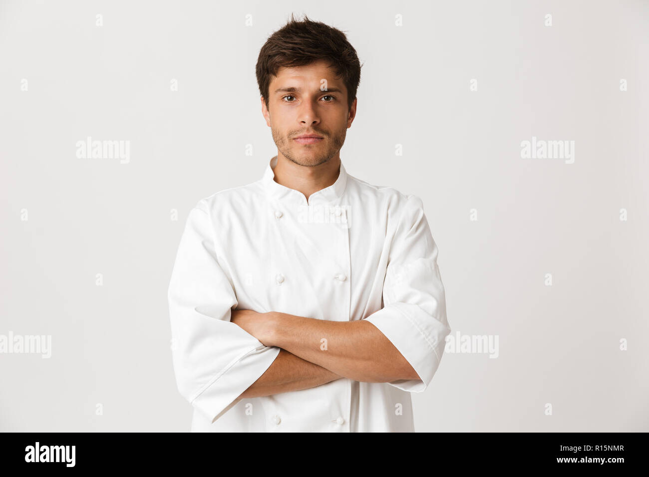 Image of handsome young chef man standing isolated over white wall ...