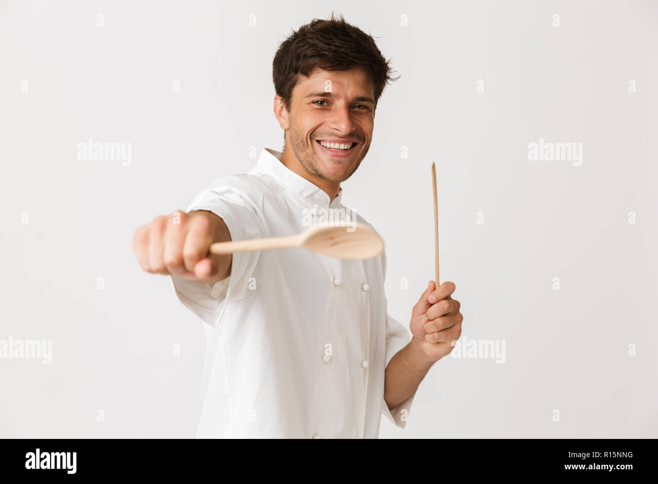 Image of handsome young chef man standing isolated over white wall ...