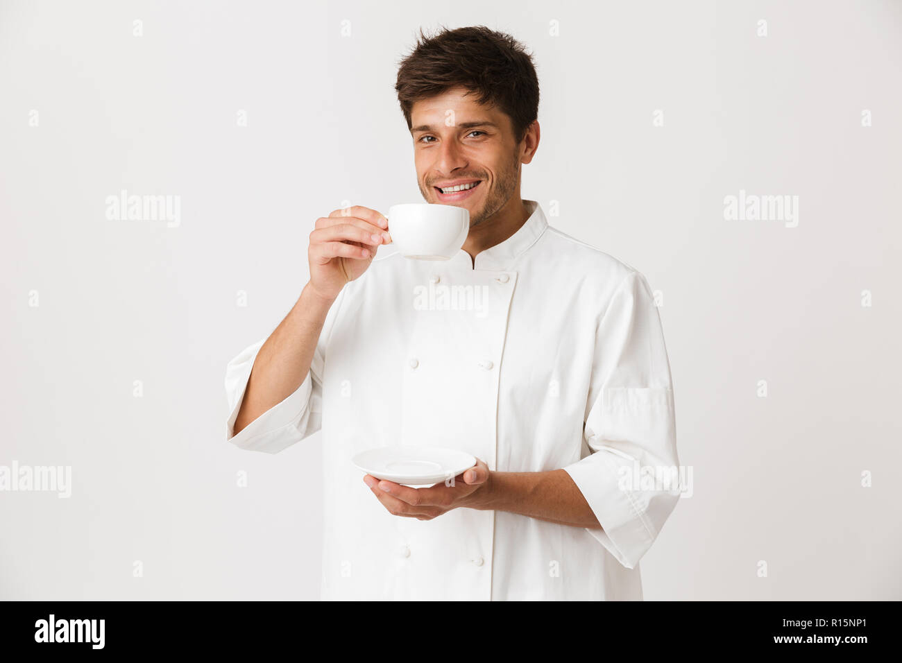 Image of emotional young chef isolated over white background holding ...