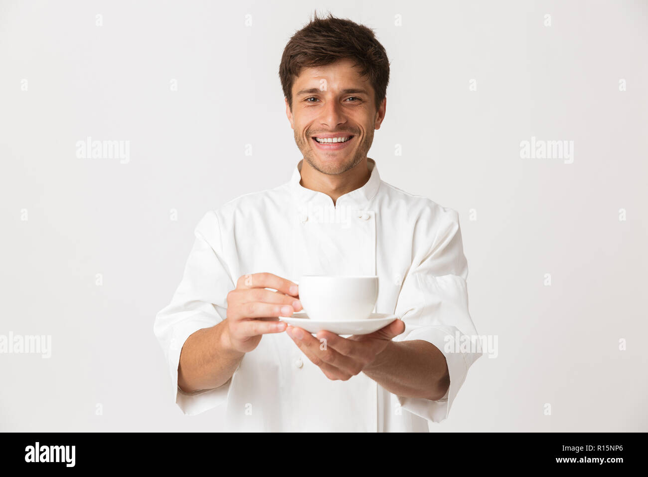 Image of emotional young chef isolated over white background holding ...