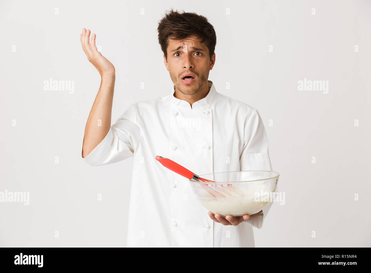 Image of confused shocked young chef isolated over white background ...