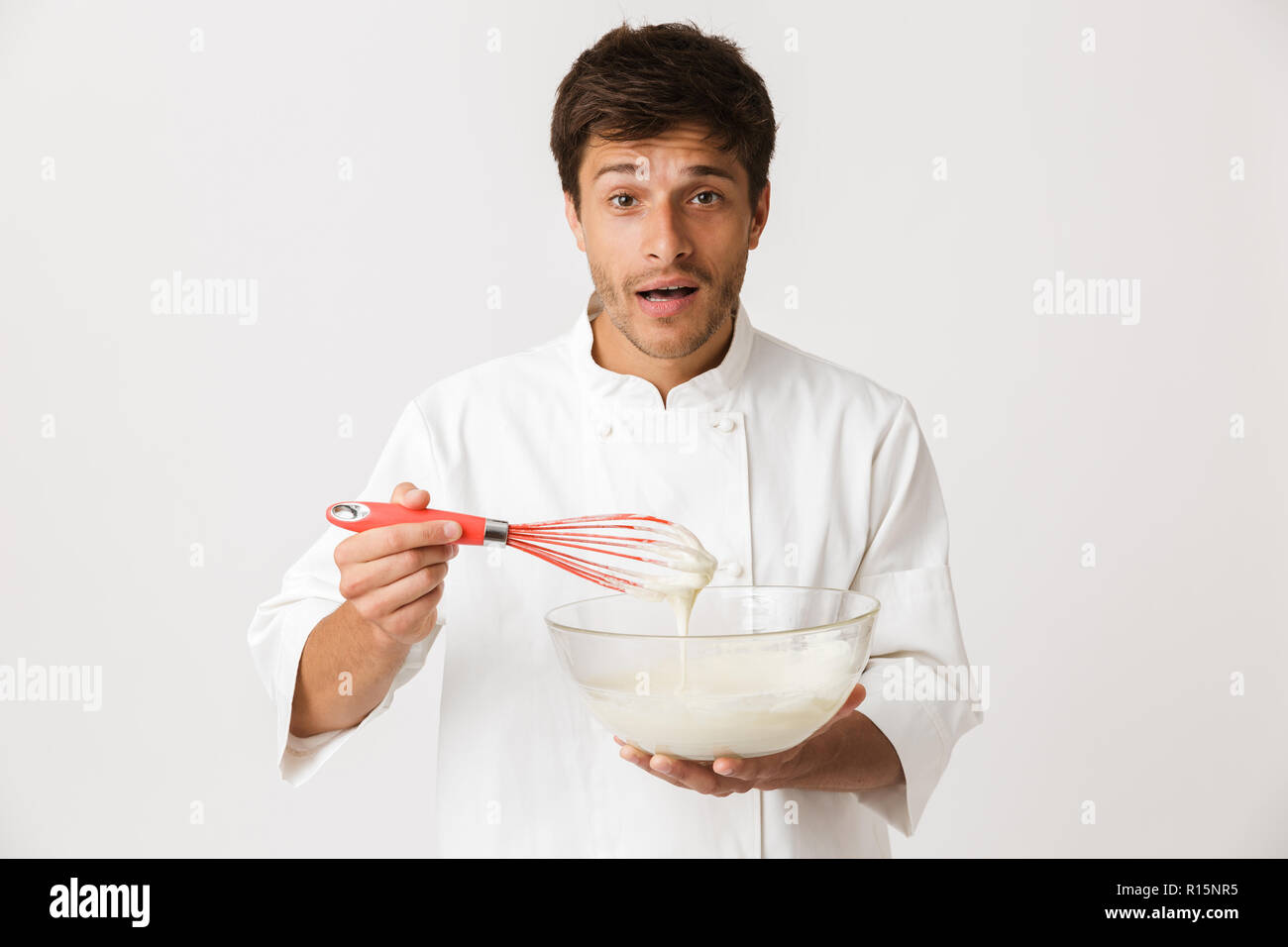 Image of shocked young chef isolated over white background cooking ...