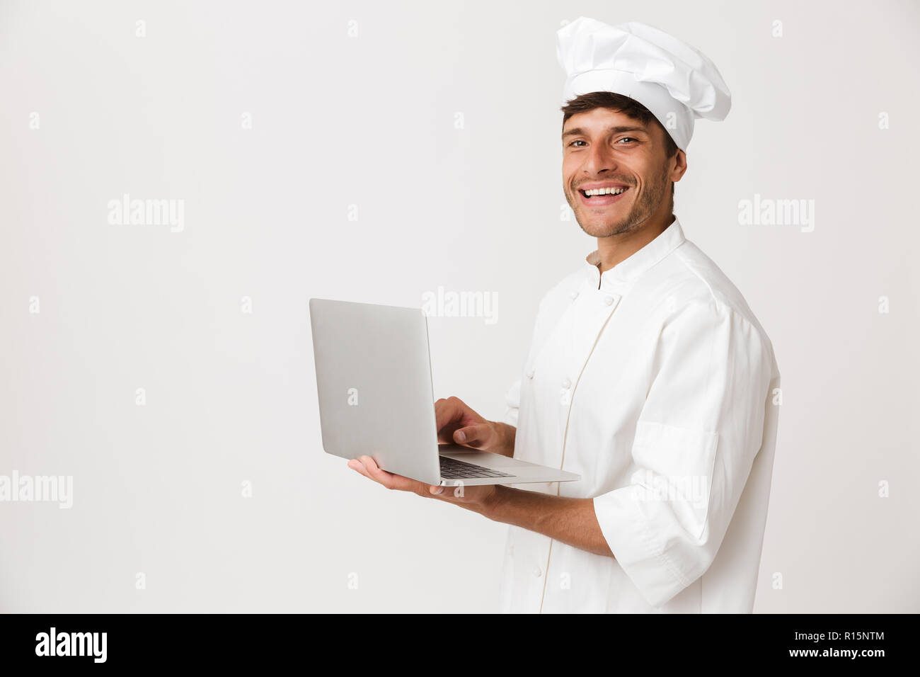 Image of handsome young chef man isolated over white wall background ...