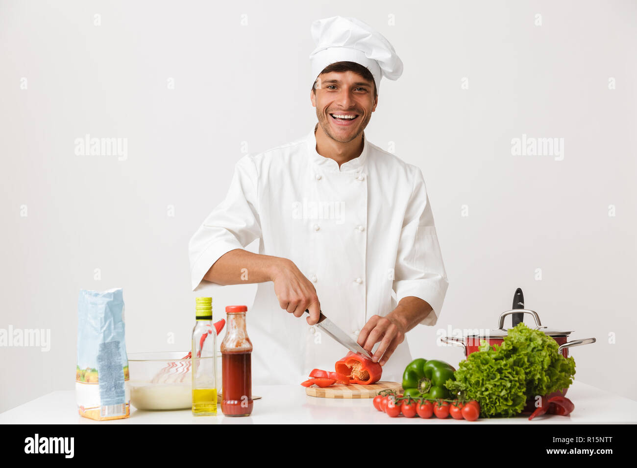Image of handsome young chef man isolated over white wall background ...