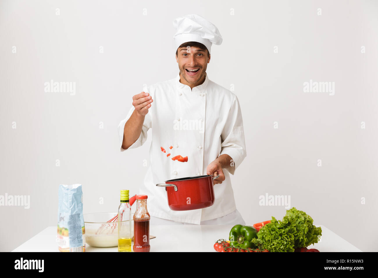 Image of handsome young chef man isolated over white wall background ...