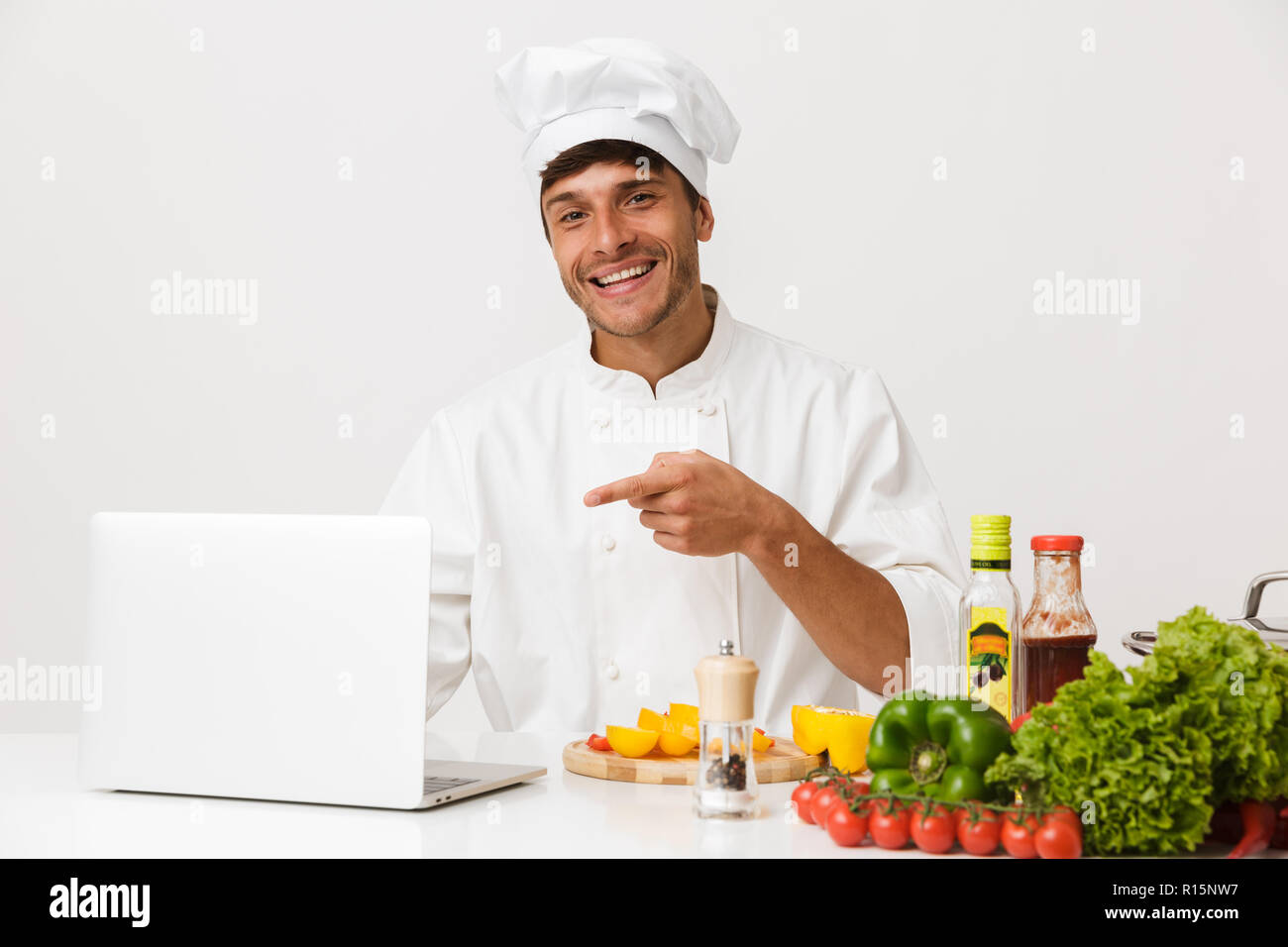 Image of handsome young chef man isolated over white wall background ...