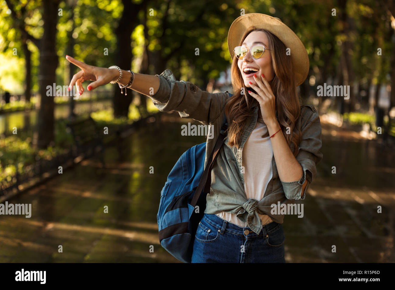 Image of excited shocked beautiful young happy woman walking outdoors ...
