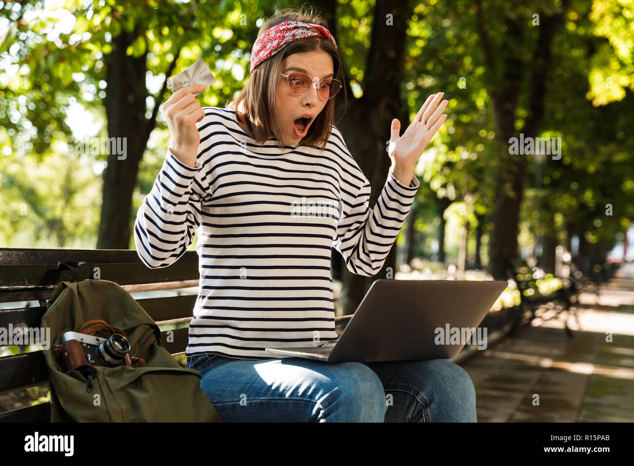 Photo of young beautiful excited happy woman outdoors sitting using ...