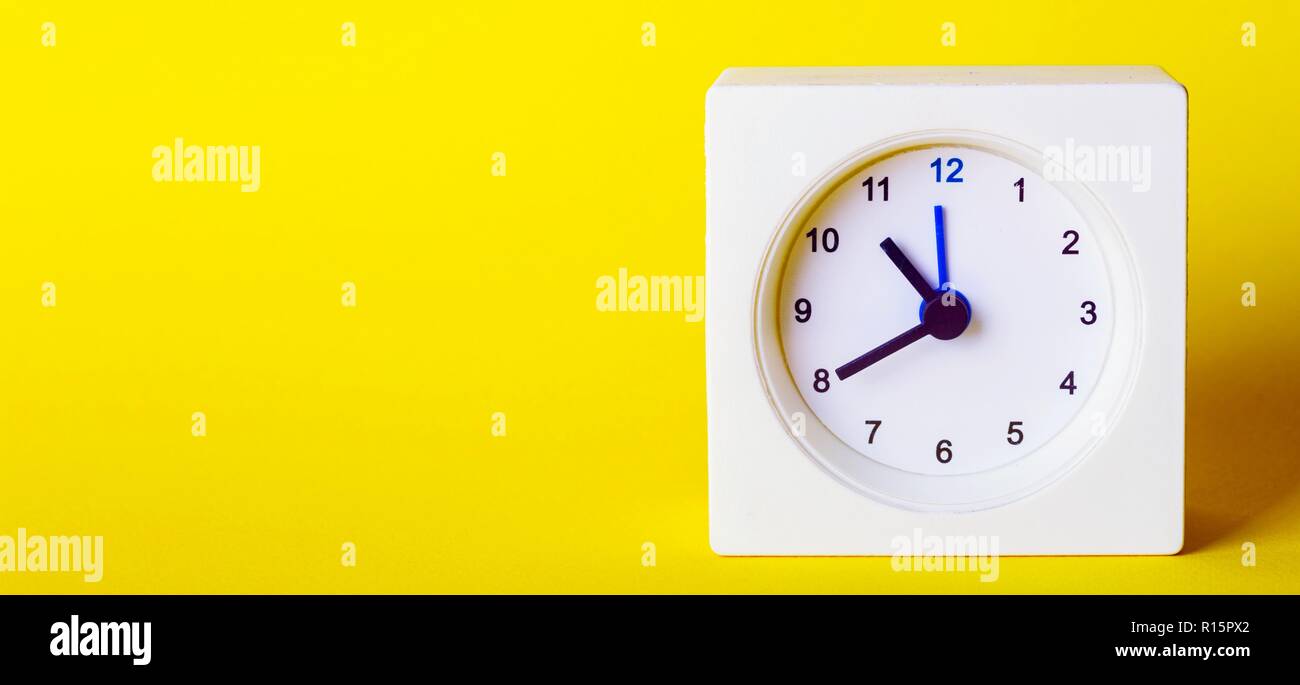 small square white clock on ayellow background Stock Photo - Alamy