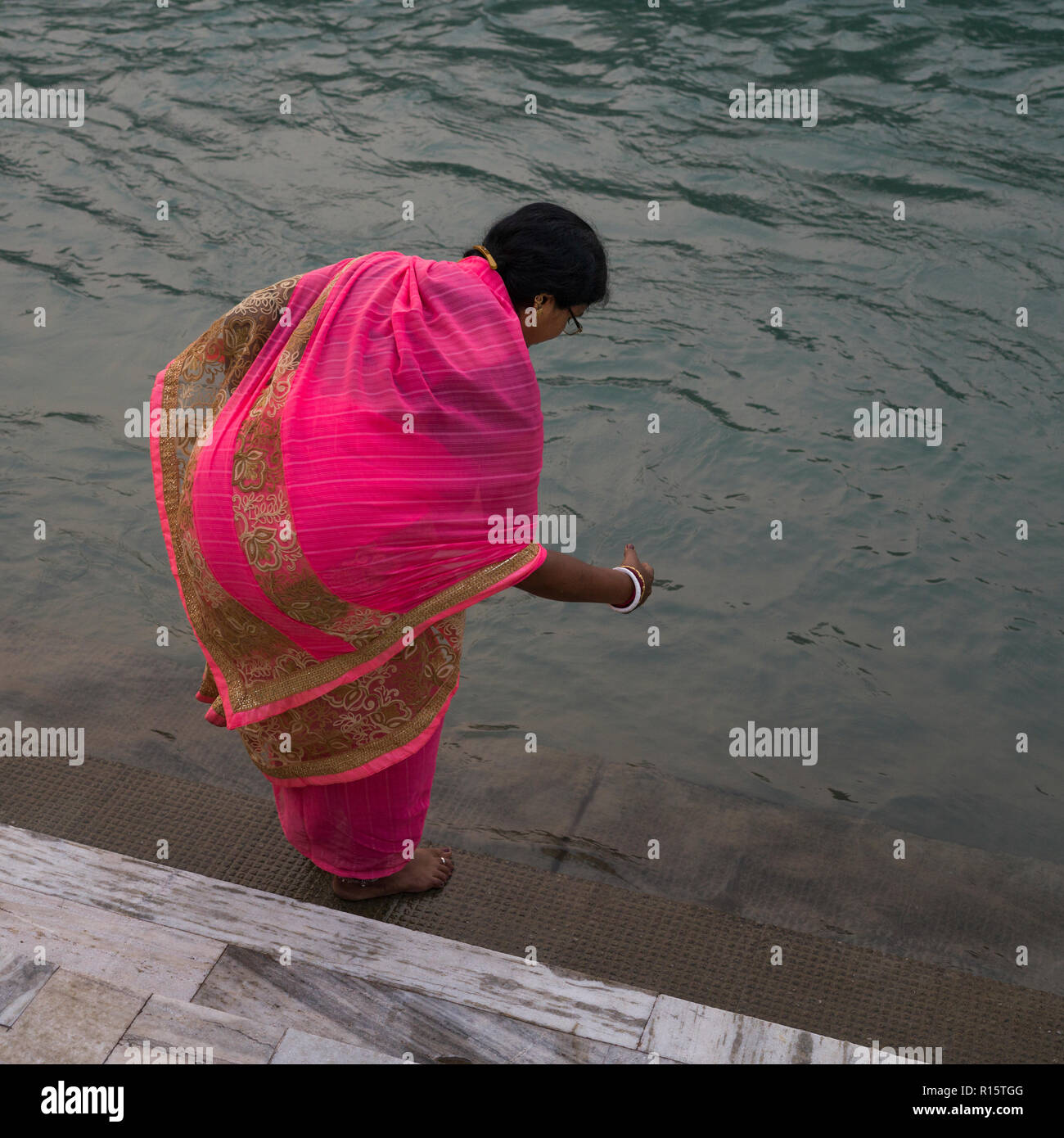 Woman performing devotional ritual on the River Ganges during Ganga ...