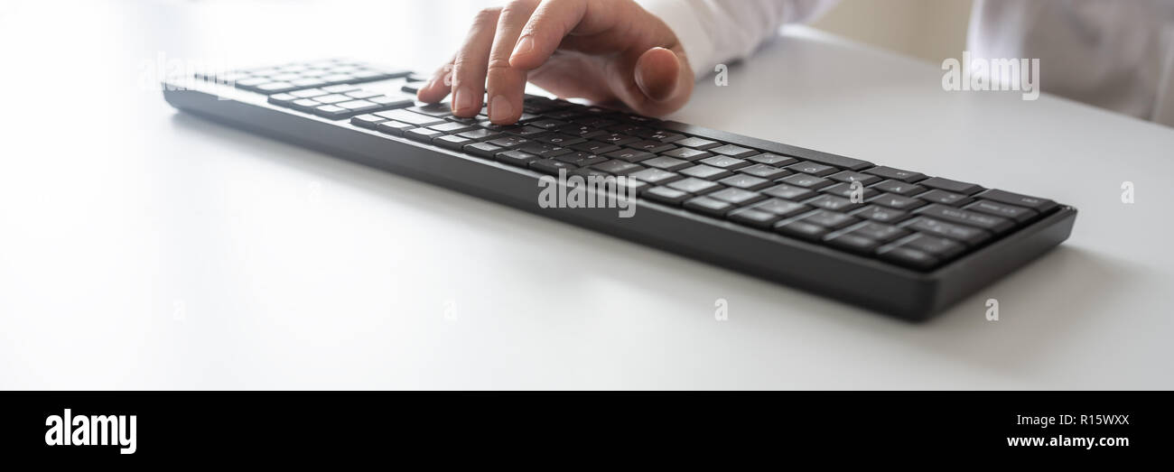 Wide view image of programmer or businessman typing on black computer ...