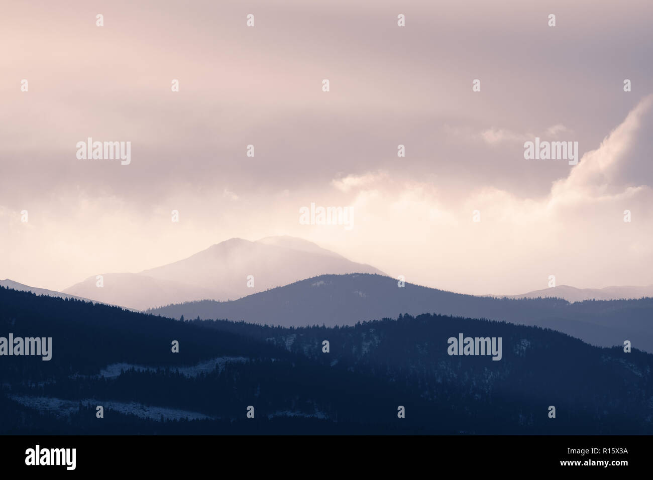 Dramatic winter storm blows over a cold barren landscape near sunset ...