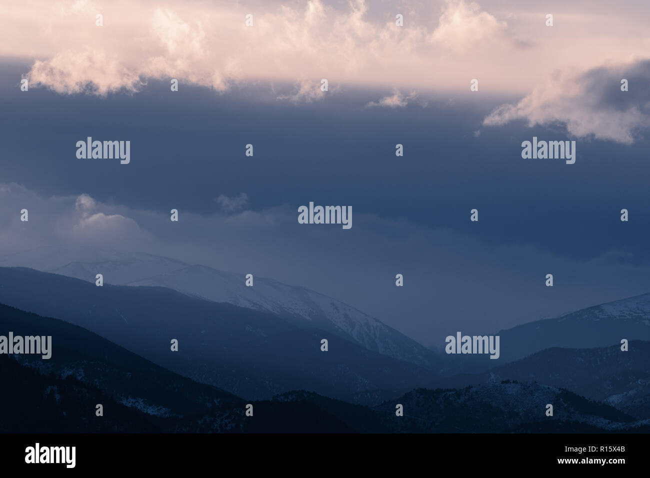 Dramatic winter storm blows over a cold barren landscape near sunset ...