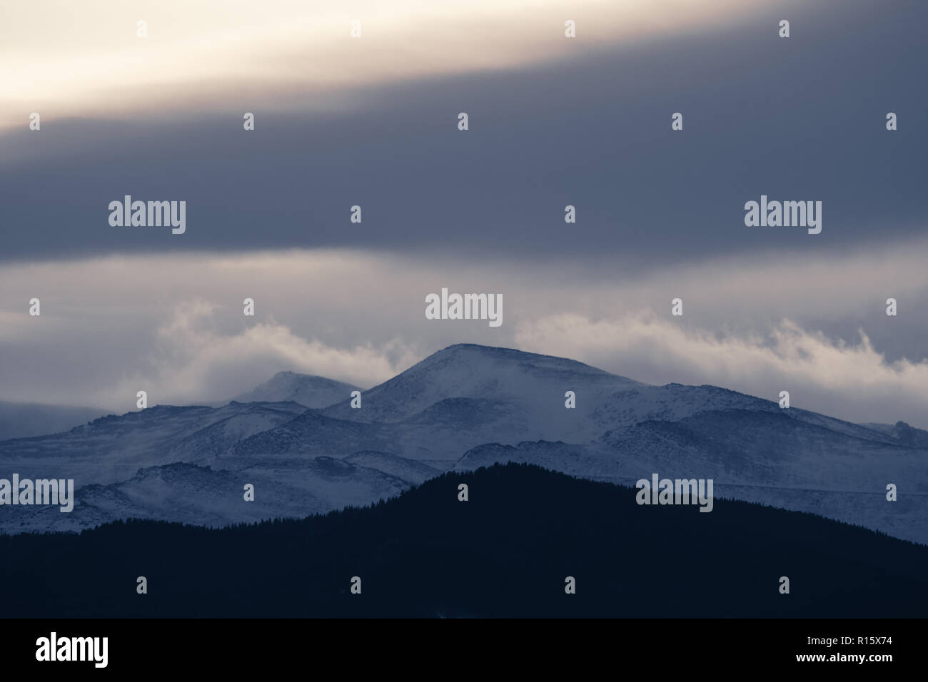 Dramatic winter storm blows over a cold barren landscape near sunset ...