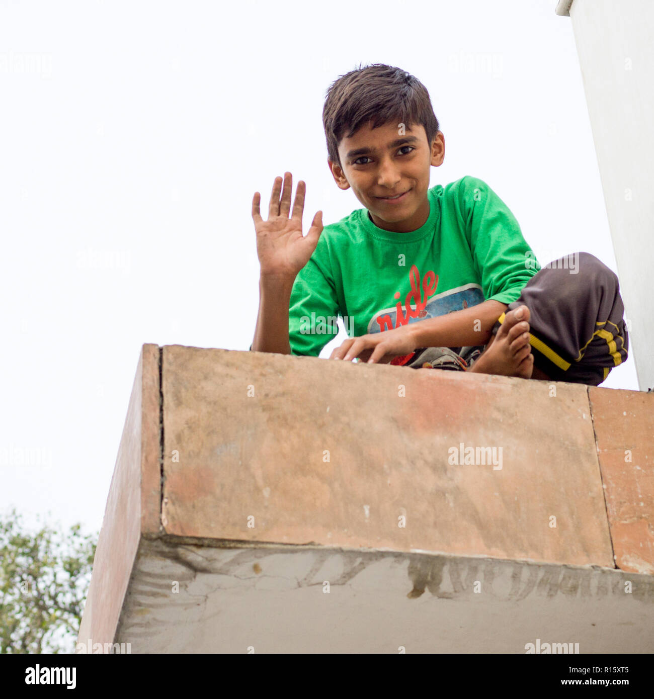 Boy waving hand from rooftop, Rishikesh, Dehradun District, Uttarakhand ...