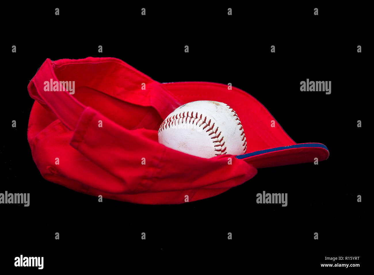 Red baseball hat isolated on black background with worn baseball ...