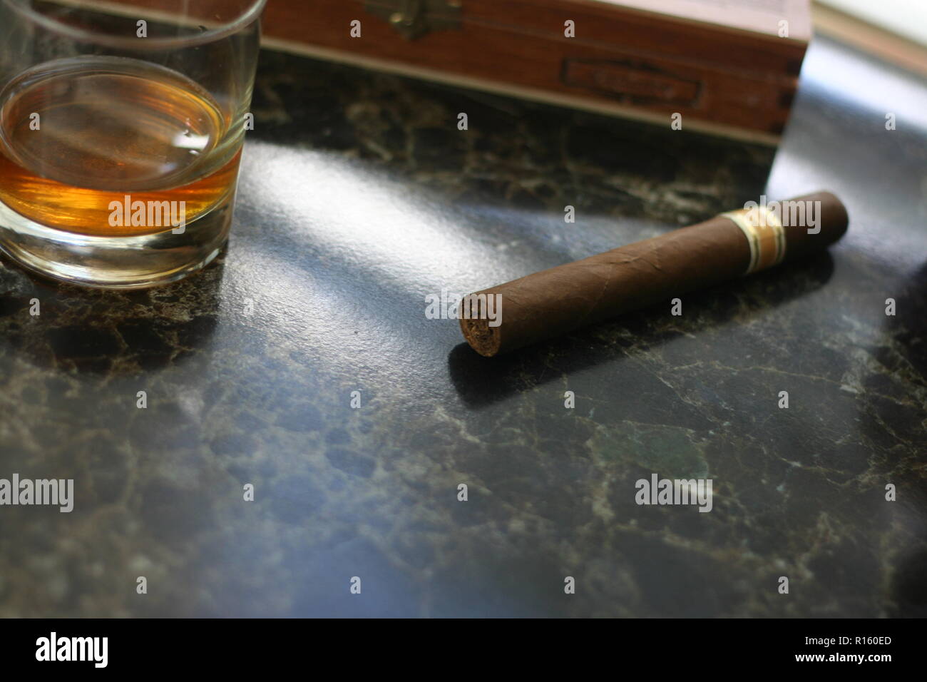 Whiskey glass, bottles and cigar on marble table Stock Photo - Alamy
