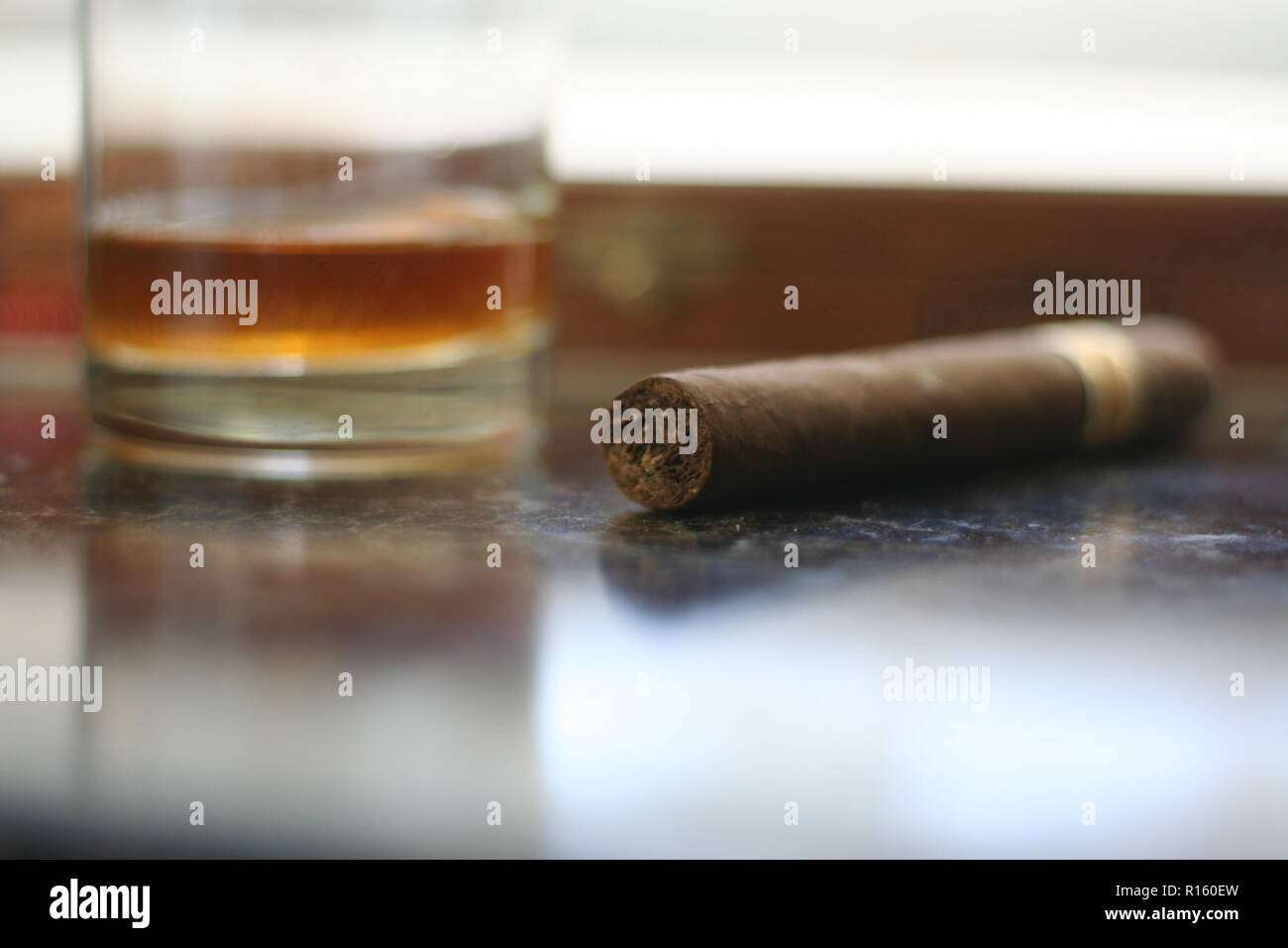 Whiskey glass, bottles and cigar on marble table Stock Photo - Alamy