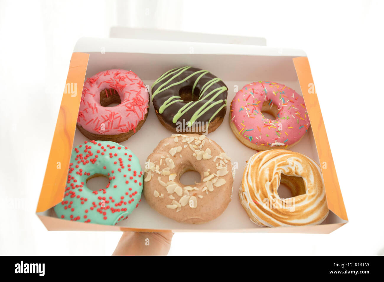 Crop hand with box of donuts Stock Photo - Alamy