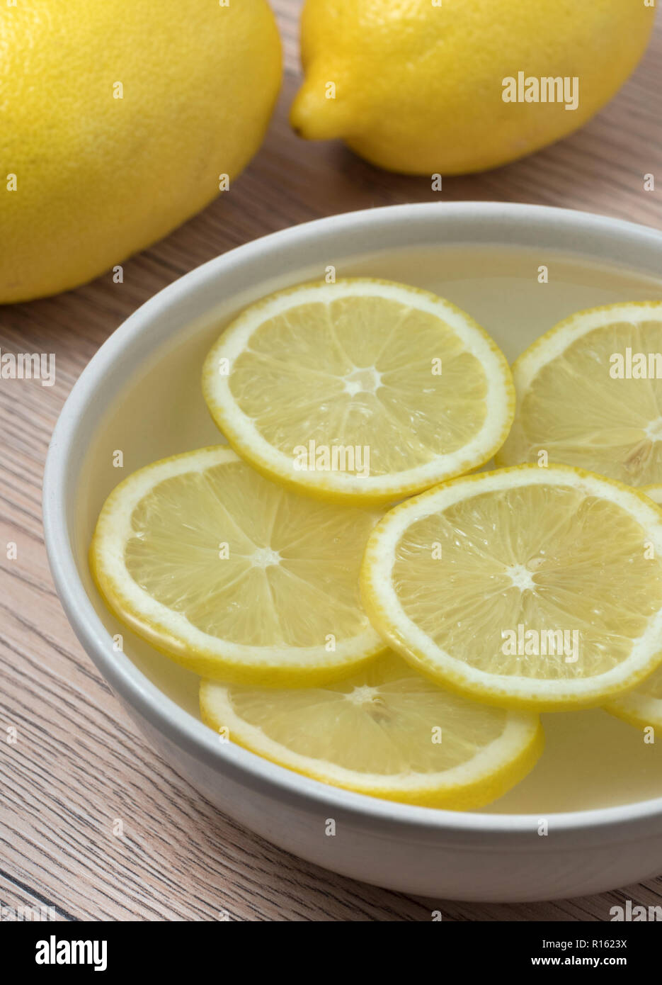 Lemon slices in a bowl with water. Close up view Stock Photo - Alamy
