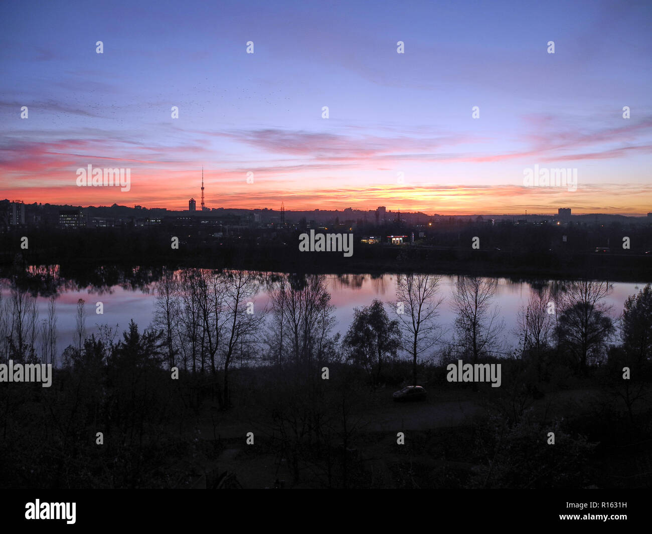 Beautiful sunset in the city view from high house window of the pond ...