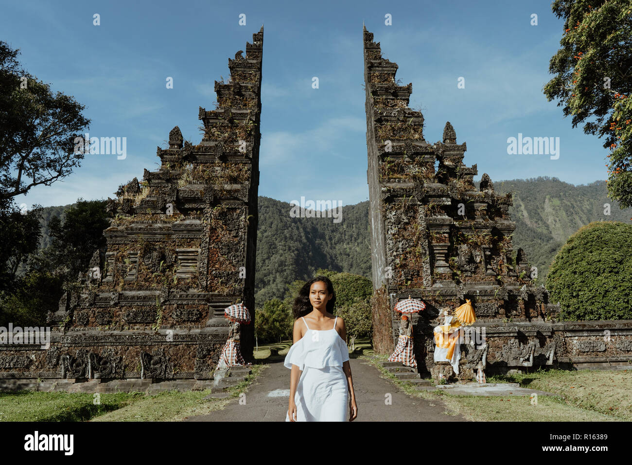 woman walking through bali traditional gate Stock Photo - Alamy