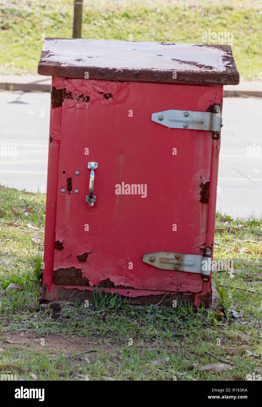 A Close up front view of a red old rusted post offcie post box storage ...