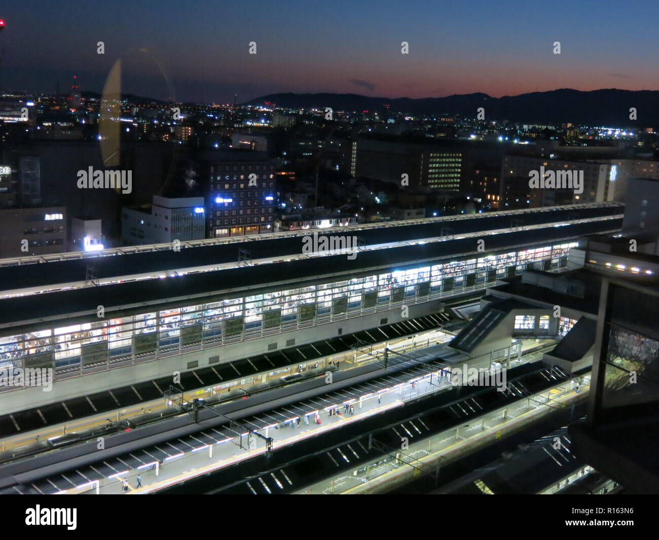 Photo of the illuminated railway station complex and multiple train ...