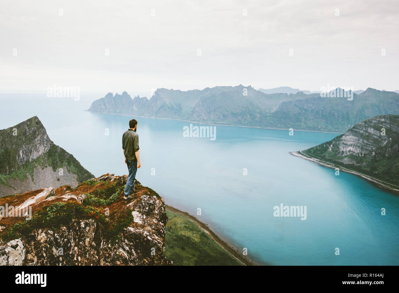 Active man traveling walking alone on cliff mountain edge above sea ...