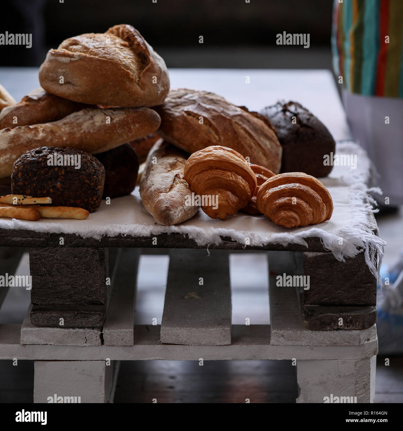Different kind of bread at white napkin on wooden pallet. Brown grain ...