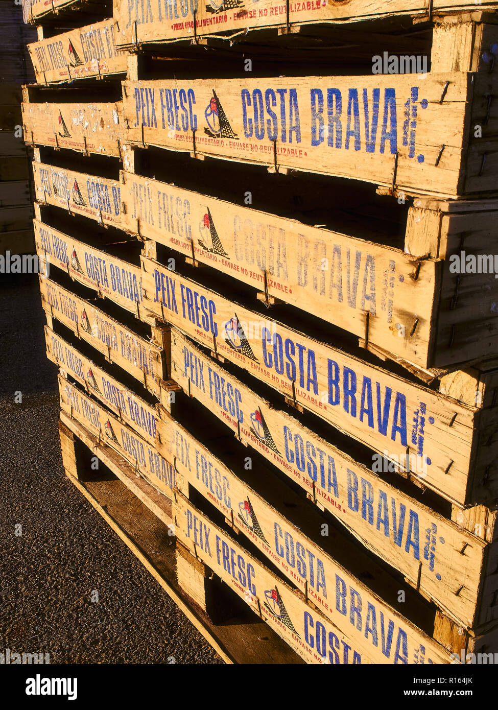 Wooden fish crates stacked labeled with the words Fresh Fish in Catalan ...
