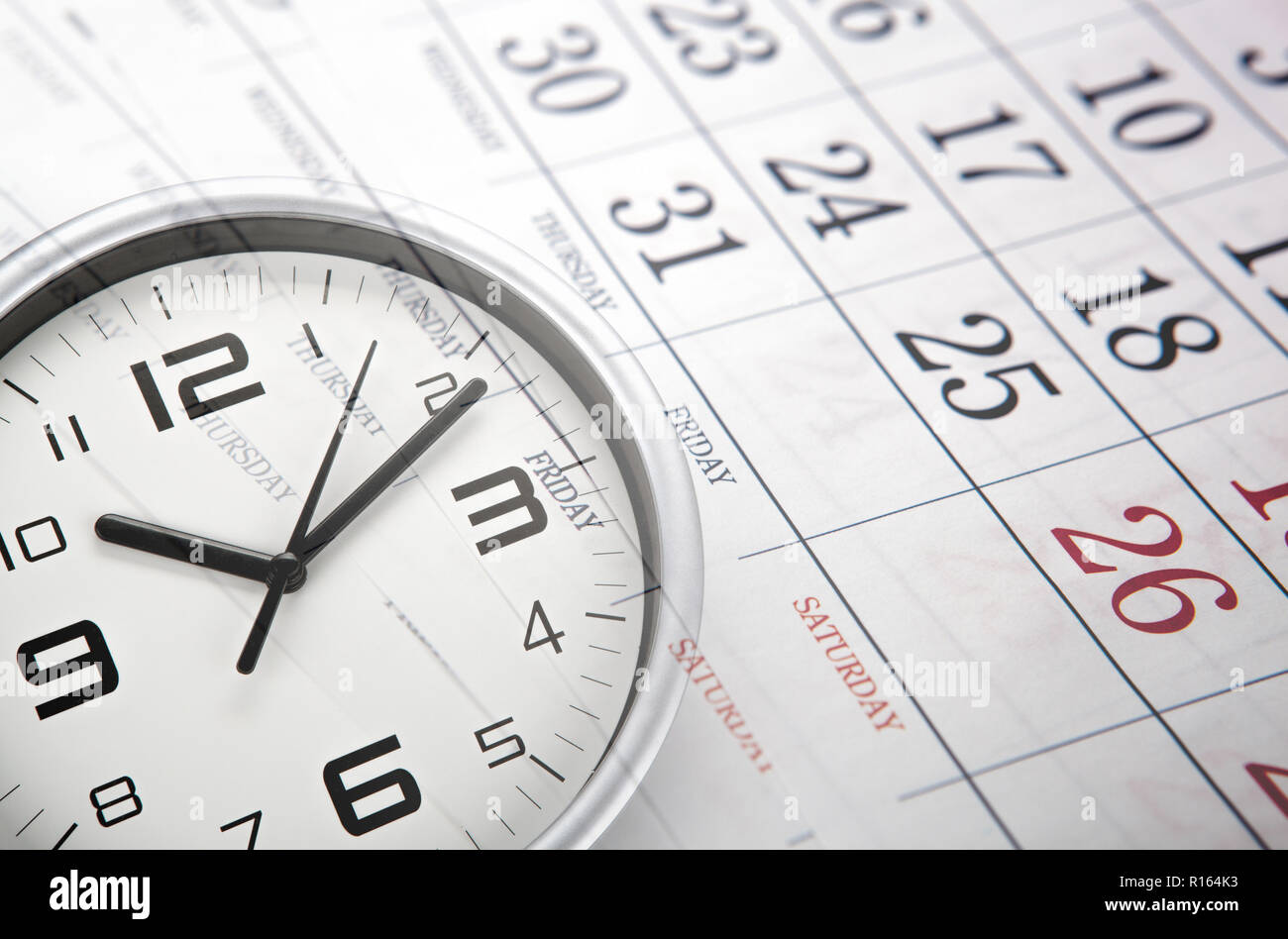 wall calendar with the number of days and white clock face closeup ...