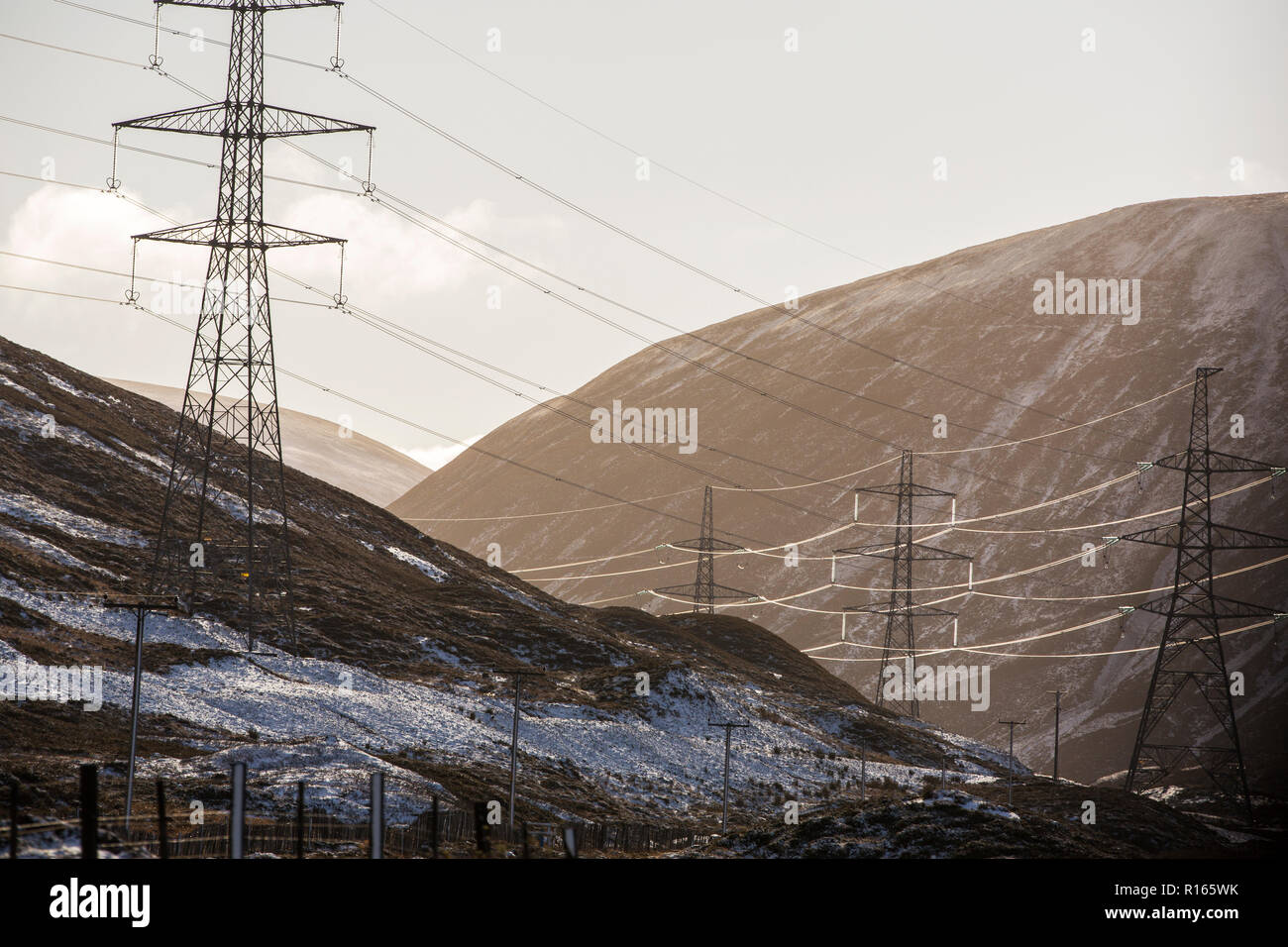 Pylons across the A9 running through mountain scenery, Scotland, UK ...