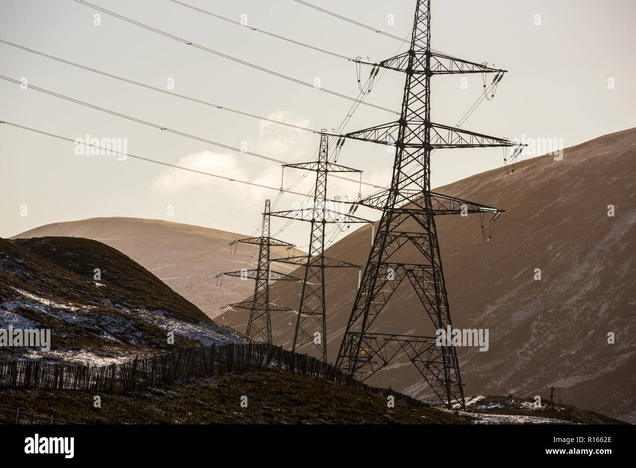 Pylons across the A9 running through mountain scenery, Scotland, UK ...