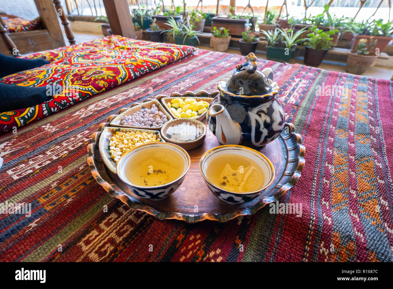 Traditional Uzbek tea and sweeties on a tapchan (traditional table/bed ...