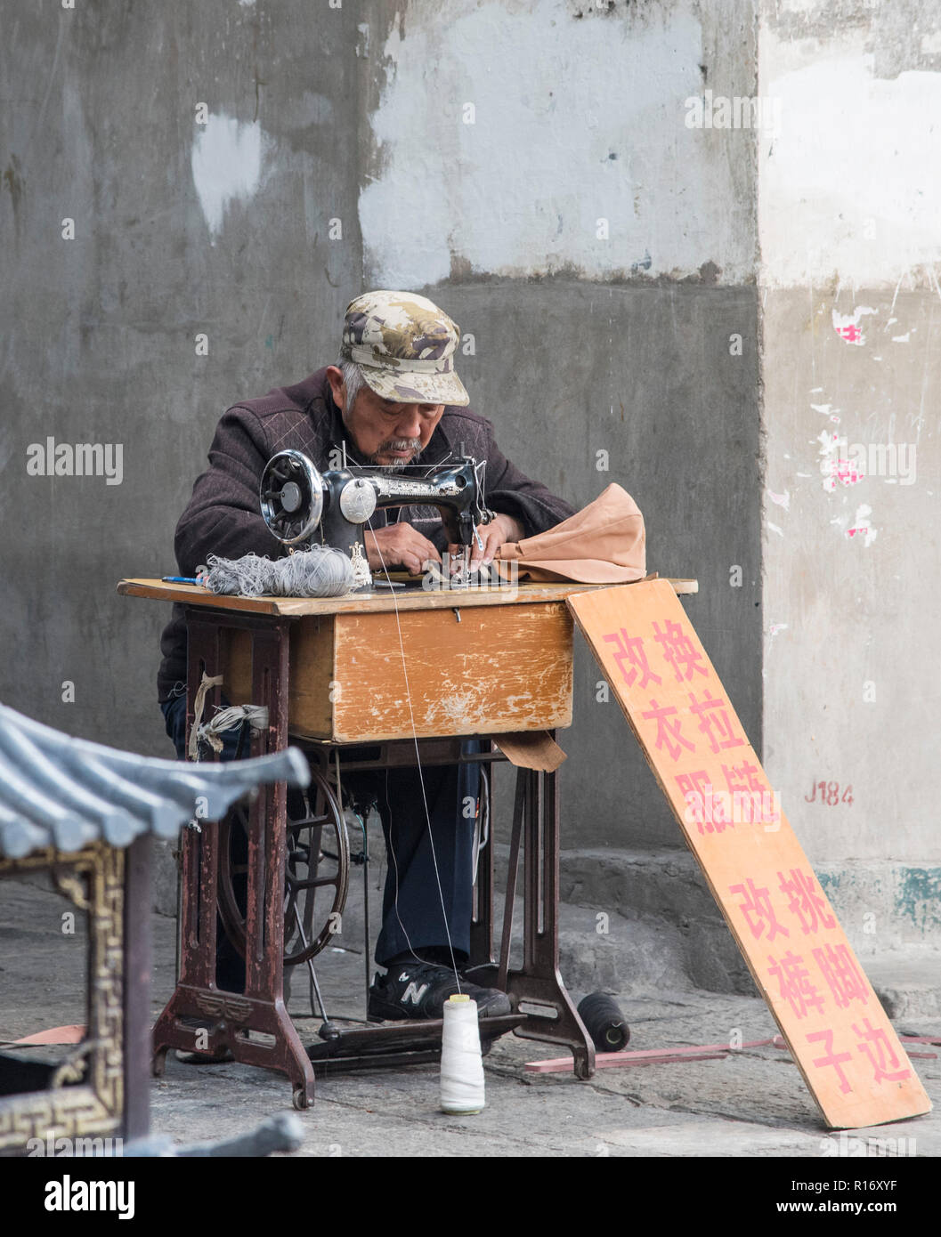 Chinese gentleman earning a living using a sewing machine. China Stock ...