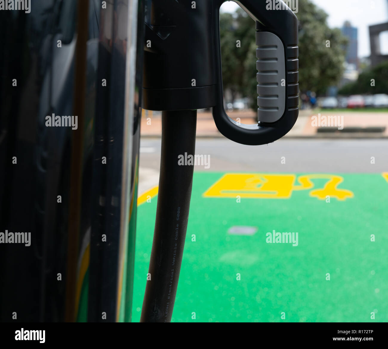 Electric vehicle charging station plugin handle from rear in selective ...