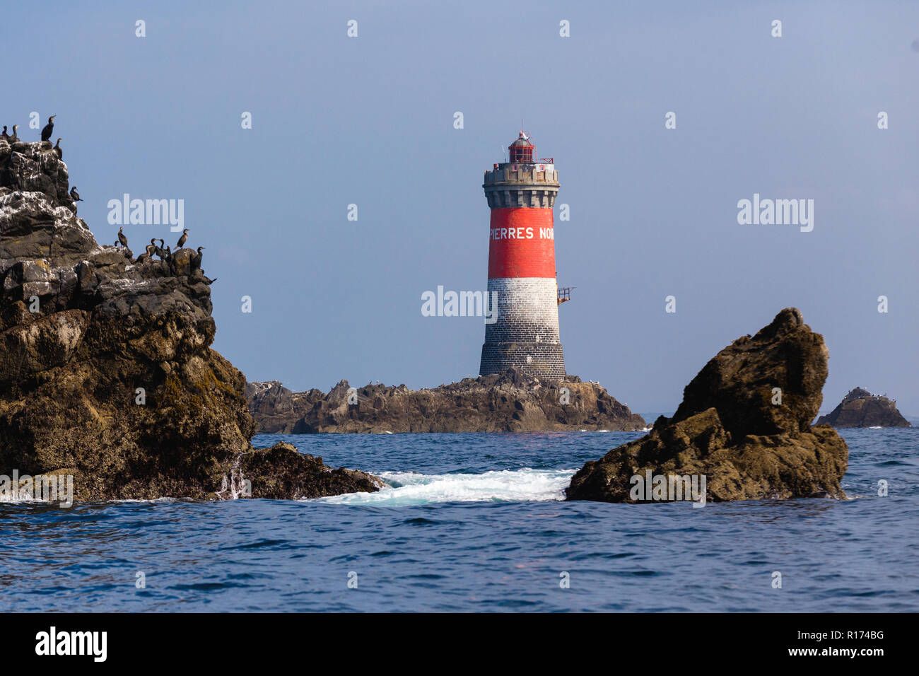 The "Pierres Noires" lighthouse in full sea, with rocks and cormorants ...