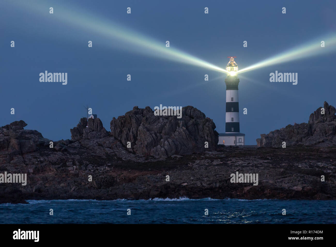 Powerful lighted lighthouse at dusk, Creach point, Ushant island ...